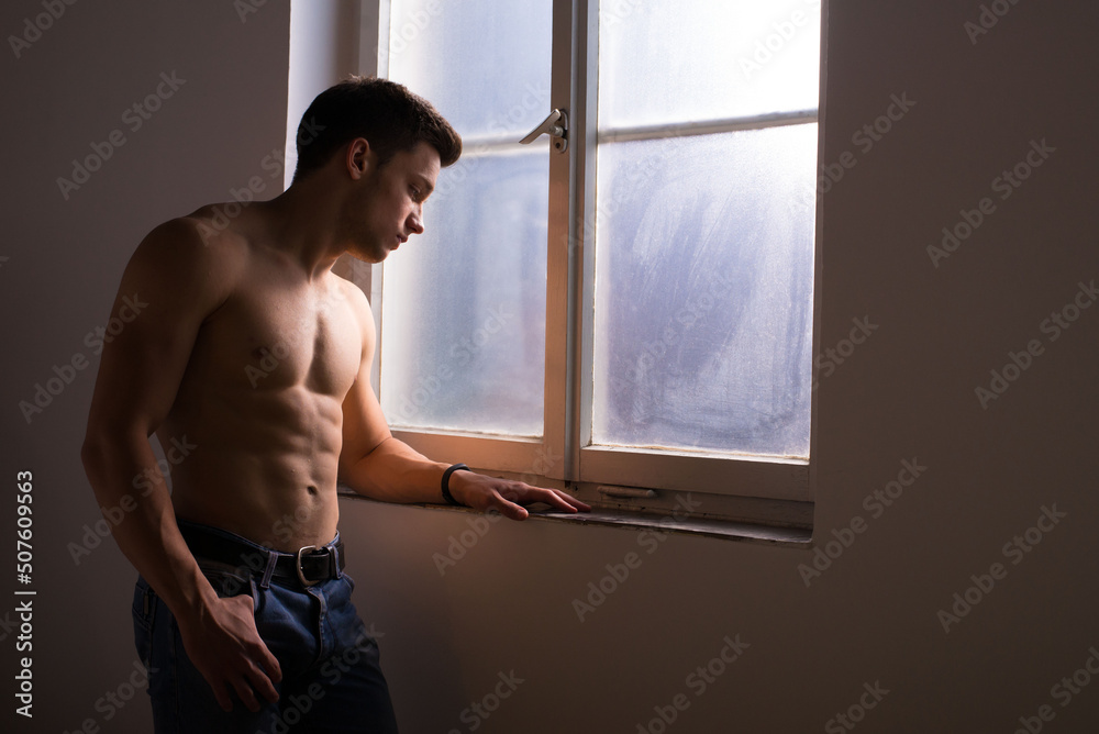 Young muscular macho man posing in studio Stock Photo | Adobe Stock