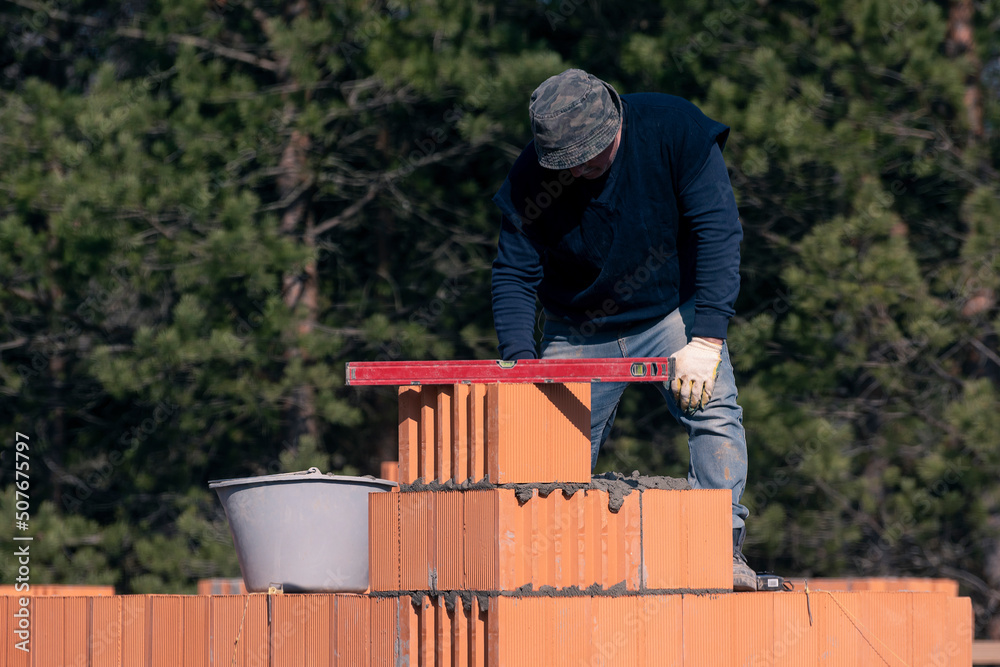 The builder will check the level of the horizontal wall of the house ...