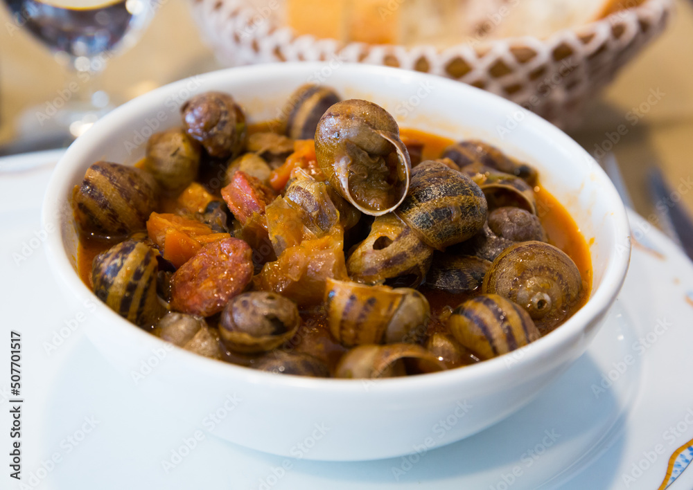 Tasty home style snails stewed with chorizo sausages in tomato sauce ...