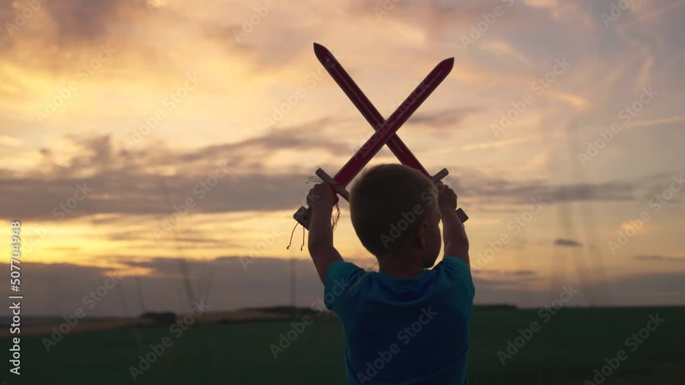 Child toy sword, children's dreams. Boy plays stands with swords raised ...