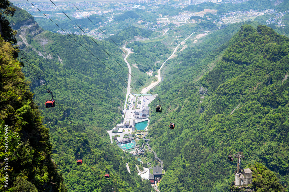 Cable car on the Tianmen mountain and Zhangjiajie town form above ...