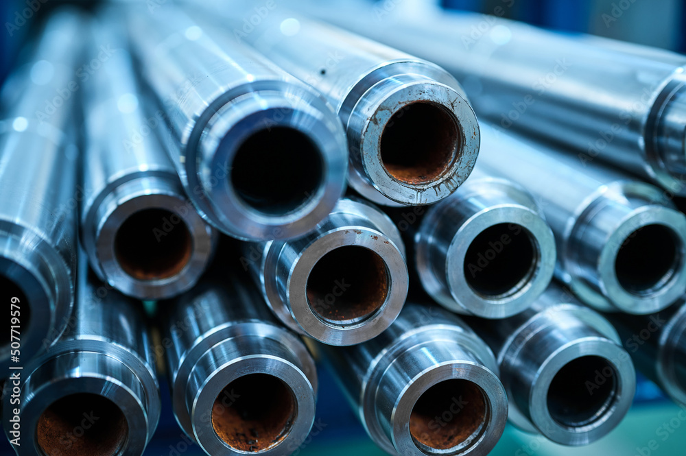 Pile of long drill rods metal workpieces in light warehouse Stock Photo ...