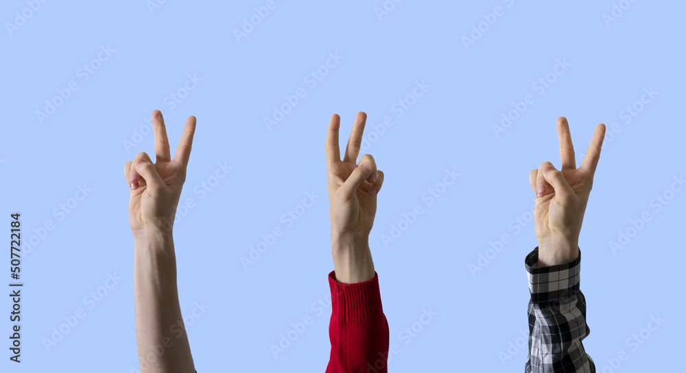 large group of people rise hands and show peace sign, no war concept ...