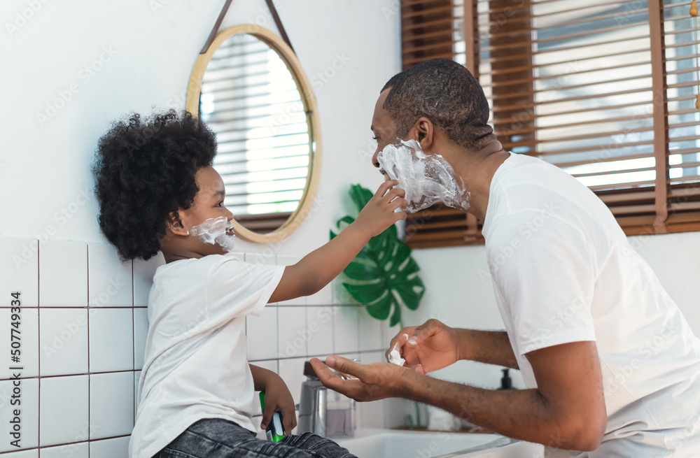 Happy African black father and little son with shaving foam on their ...