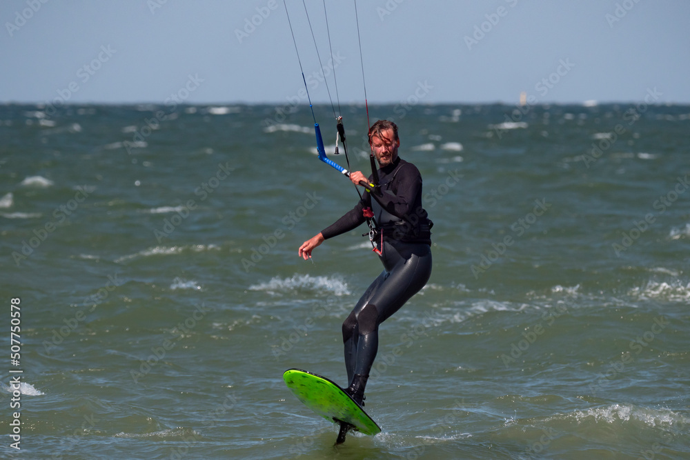 Male Kite Foil Surfer with beard and long hair on the sea. Stock Photo ...