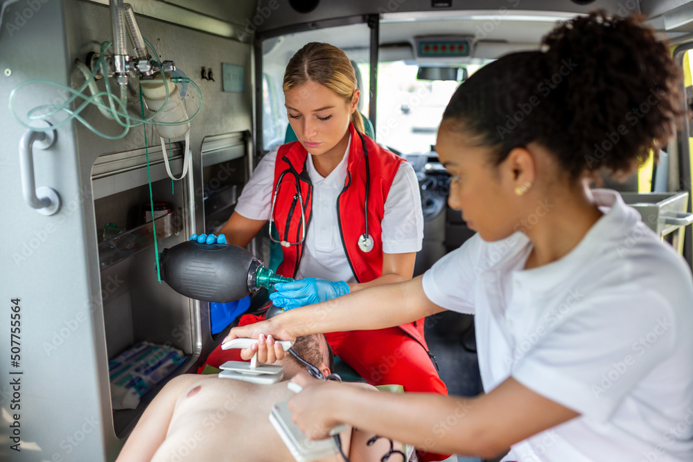 Paramedic using defibrillator (AED) in conducting a basic ...