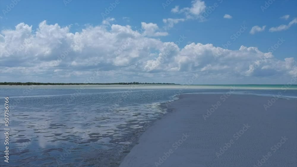Arial footoge of two people walking on a sandbar in shallow blue ...