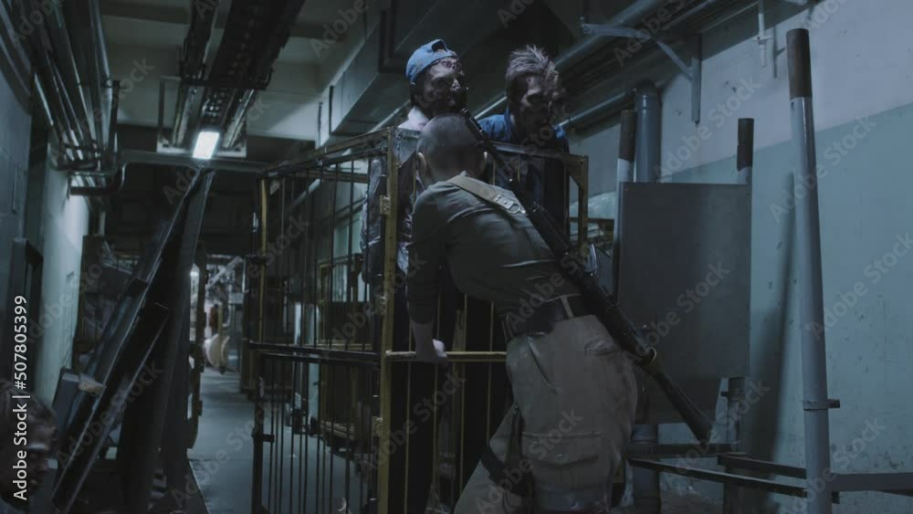 Injured female soldier with shaved head transporting zombies in cage on ...