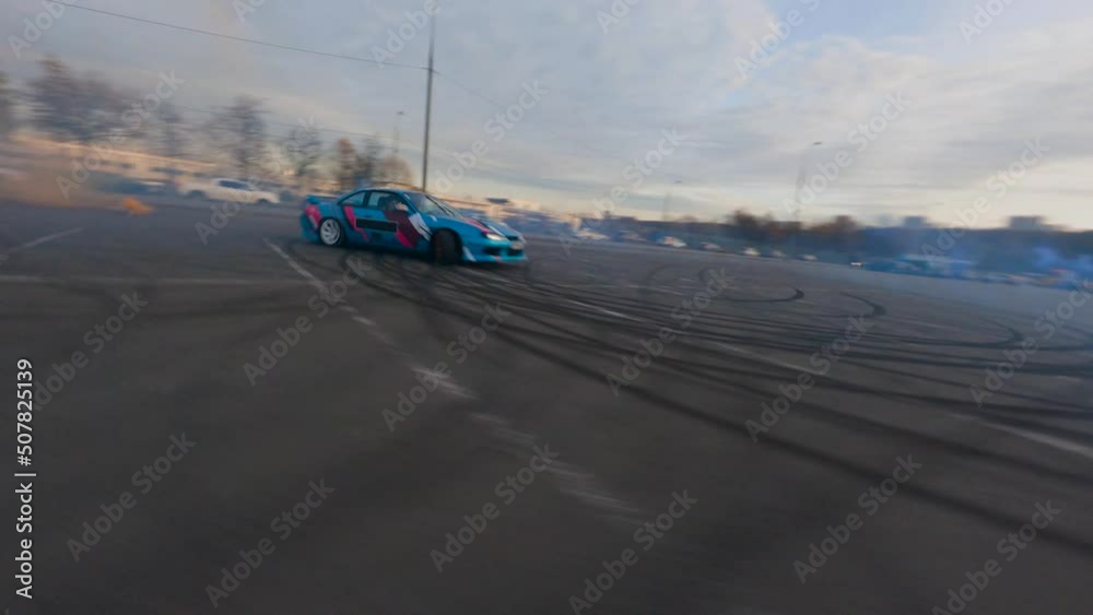 Spectacular aerial of fpv drone orbiting around drifting fast sport car ...