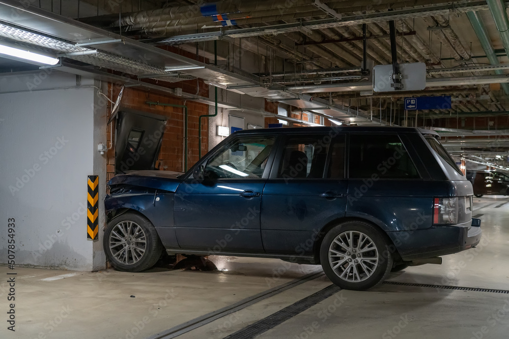 Huge SUV car drove through a door in the wall in an underground parking ...