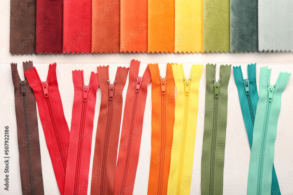 Stylish different zippers and fabric samples on light background Stock ...