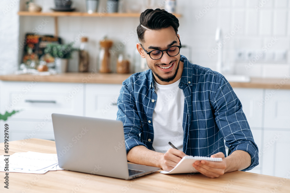 Happy charismatic arabian or indian guy with glasses, sitting at the ...