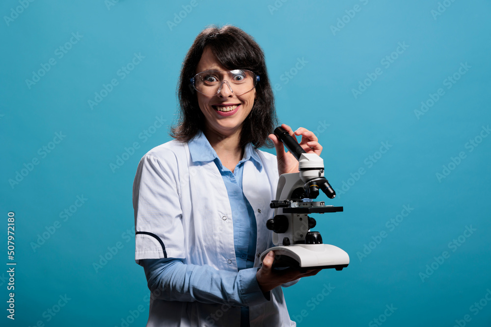Insane looking scientist smiling creepy while having modern microscope ...