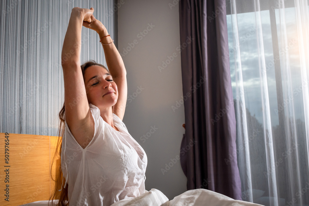 Mujer levantándose de la cama a la mañana luego de una buena noche de ...