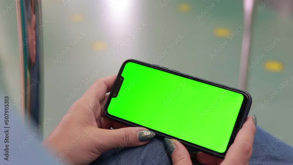 Female hands are holding a smartphone and touching the screen with ...