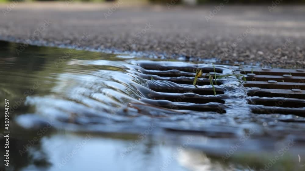 water flowing down a manhole in slow motion. ground view of rainwater ...
