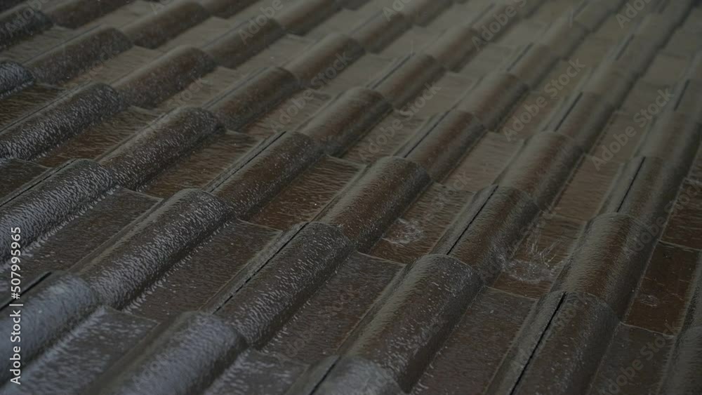 slow motion rainy season, heavy rain water downpour on black tile roof ...