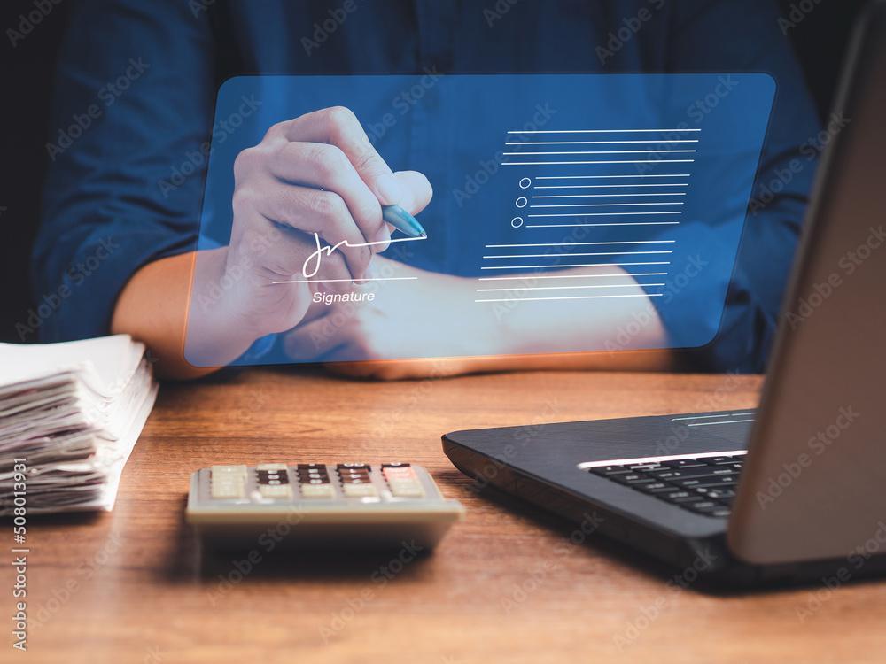 A businessman uses a pen to sign electronic documents on digital ...