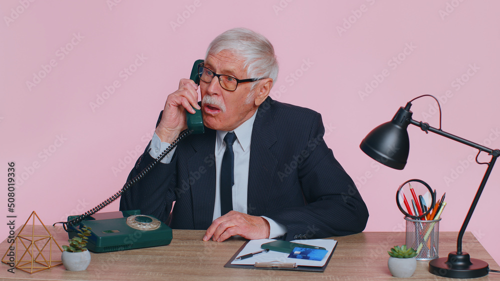 Crazy senior businessman talking on wired vintage telephone of 80s ...