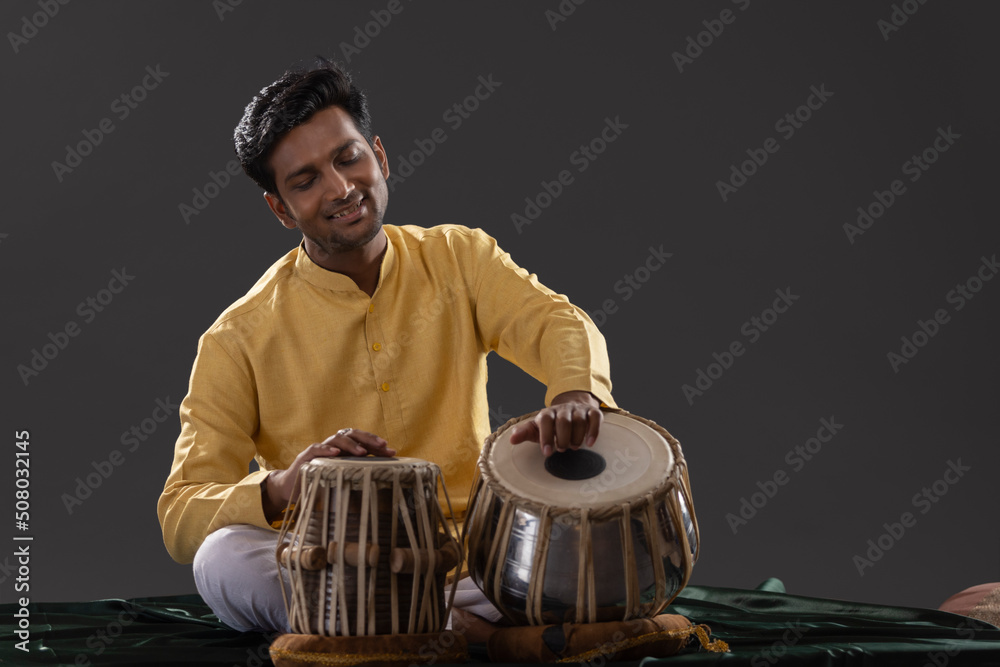 Portrait of young man performing with Tabla on stage Stock Photo ...