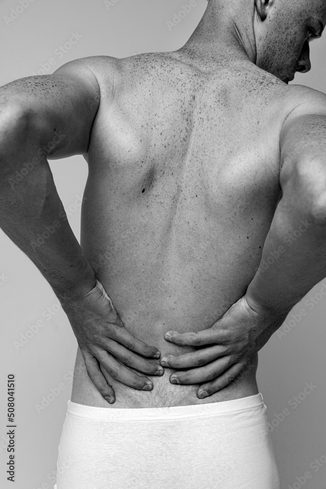 Half-length portrait of muscular male back isolated over grey studio ...