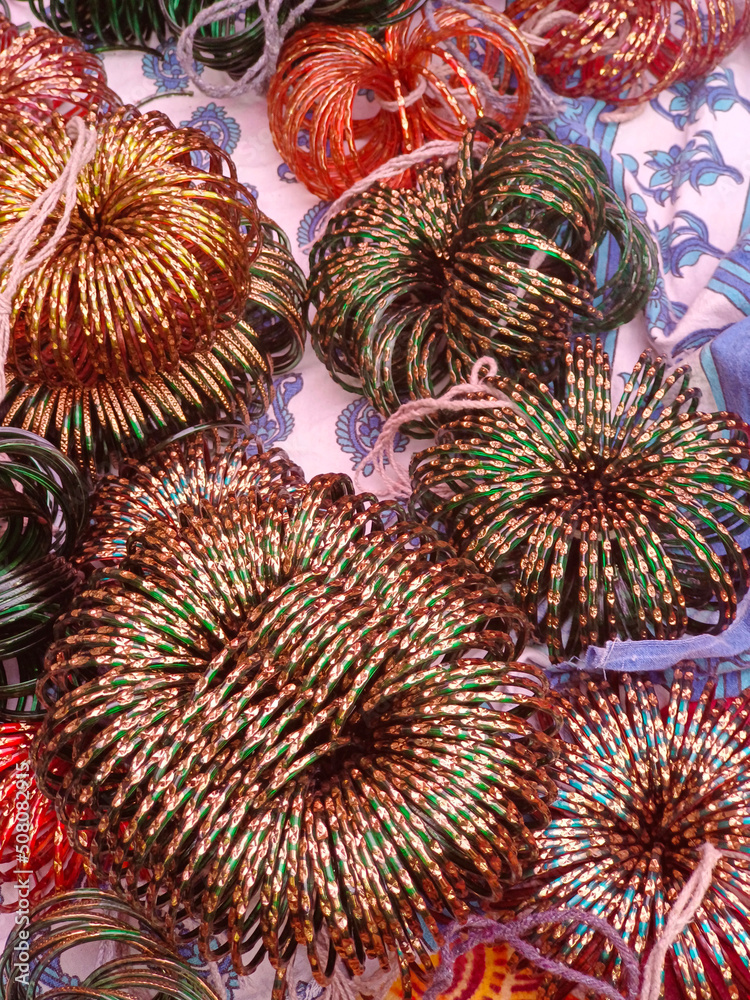 Pre wedding ceremony a lady bangle seller is putting green glass ...