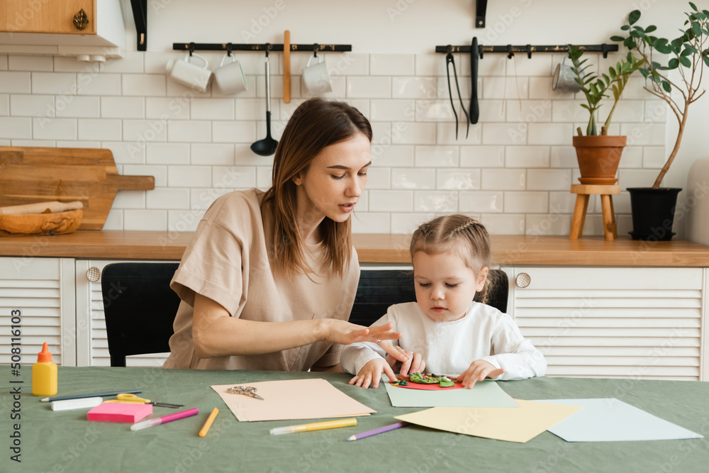 Mother and little daughter enjoy a creative morning by making crafts ...