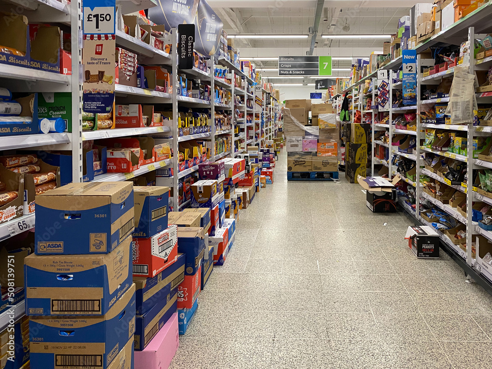 Boxes of products in a supermarket aisle ready to be unloaded onto ...