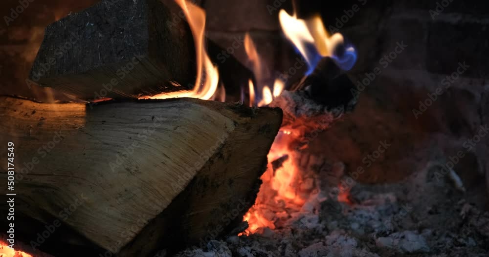 burning log. flickering fire of burning logs in the dark. copper ...