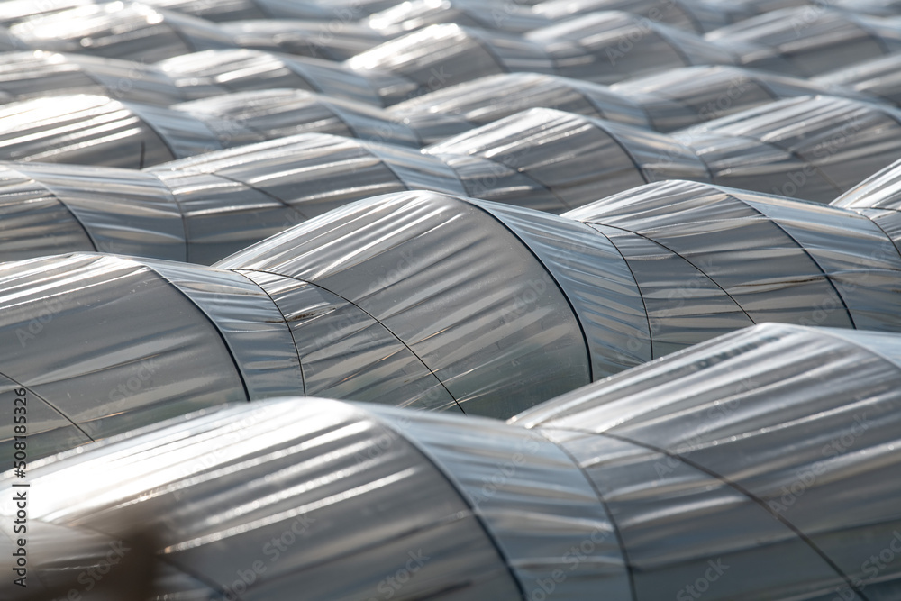 Farm plantation covered under agricultural plastic film tunnel rows ...