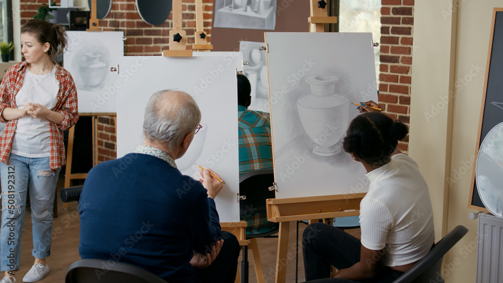 Multi ethnic team of people learning drawing technique together in art ...