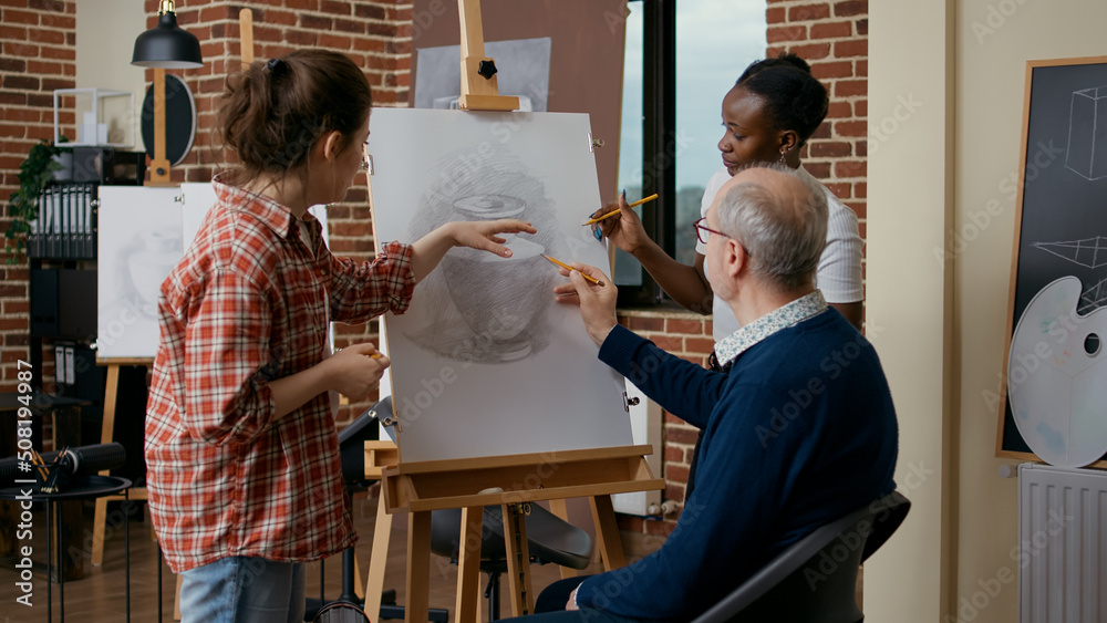 Teacher and student helping old man to draw vase on canvas, explaining ...