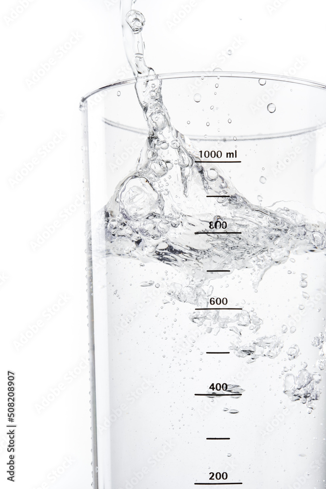 Pouring water into glass on white background. Stream of water into a ...