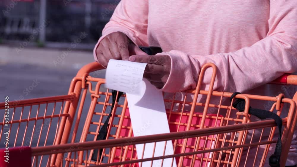 Video Stock Woman checks paper receipt near shopping grocery store ...