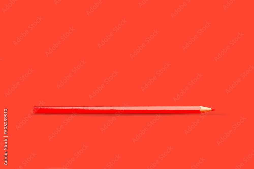 Lápiz de color rojo de madera sobre un fondo rojo liso y aislado. Vista ...