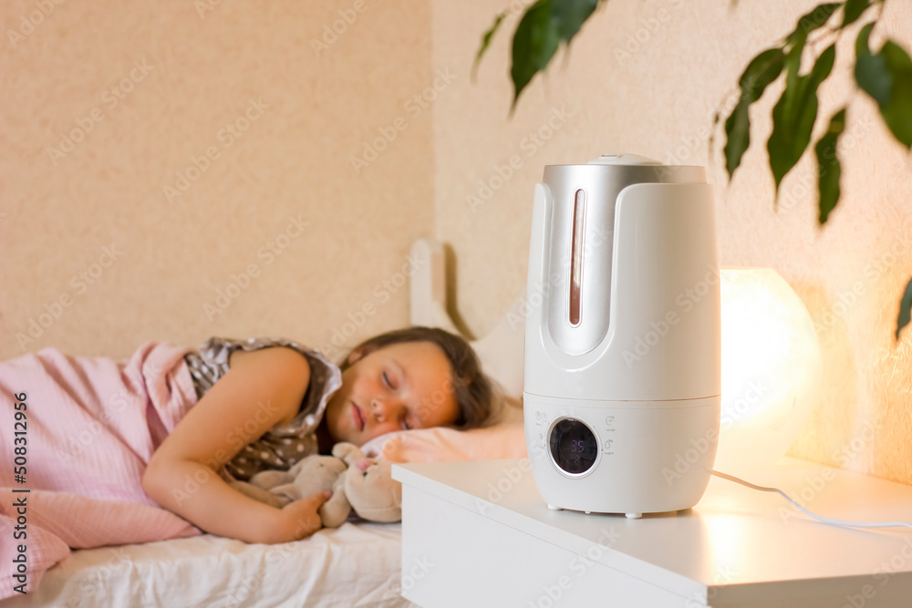 Cute little girl sleeping in bedroom with air humidifier. Stock Photo ...
