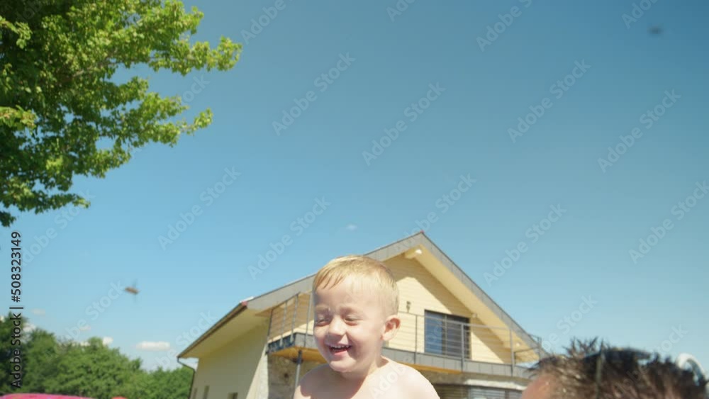 LOW ANGLE VIEW: Father throwing his baby son in the air while playing ...