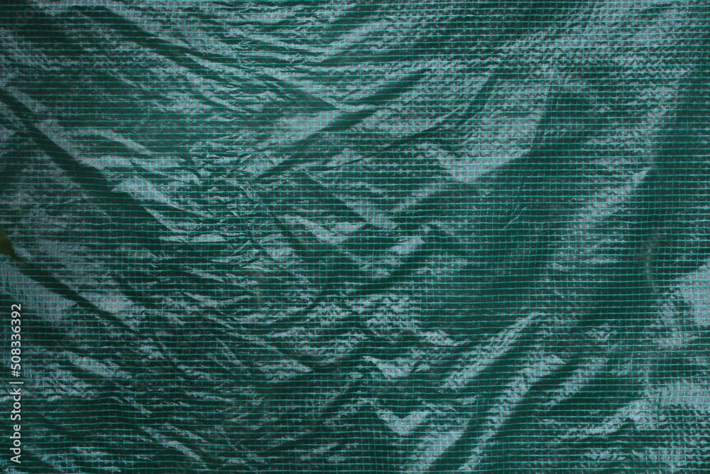 Front view of the green plastic cover of a greenhouse. Background ...