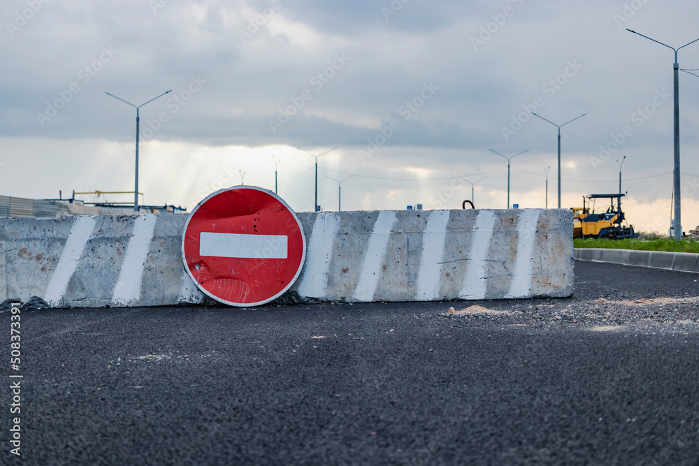 A stop road sign and concrete blocks block the entrance to the ...