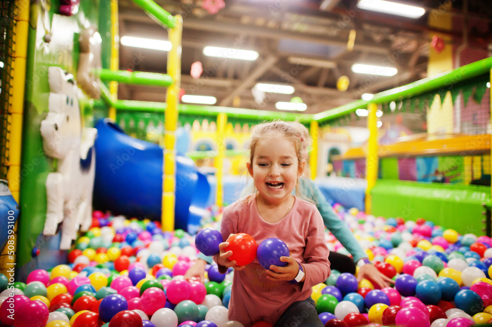 Child playing in colorful ball pit. Day care indoor playground. Balls ...