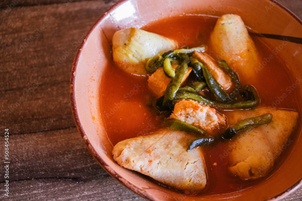 Corundas en salsa roja con chile poblano y carne de cerdo Stock Photo ...