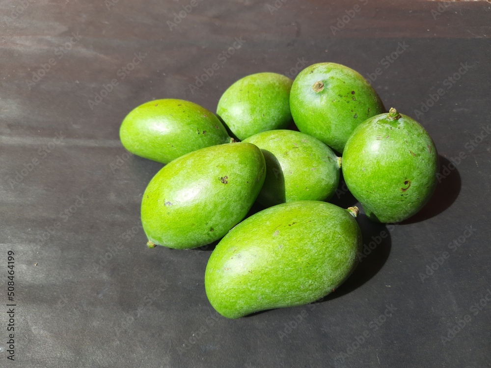 Raw mango in black background. Mango is a popular fruit, it is also ...