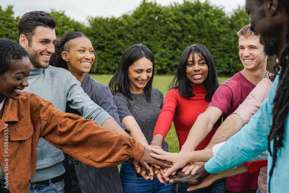 Young multiethnic group of people stacking hands together outdoor ...