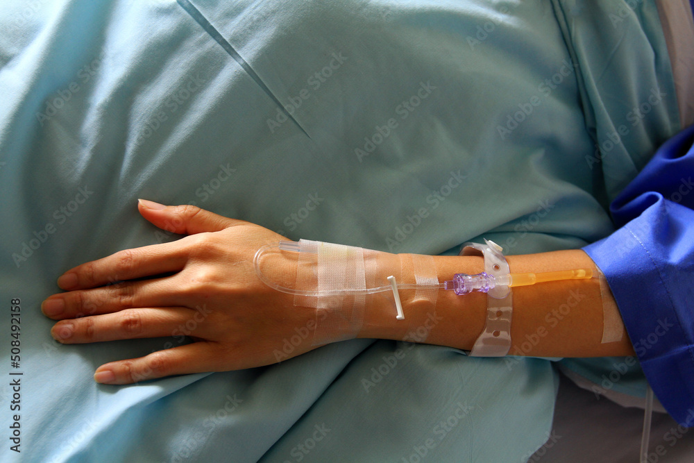 Close up the patient's hands and arms are giving the saline solution on ...