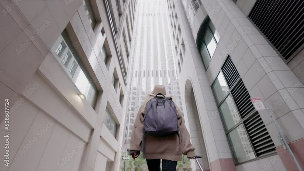 Motion background for urban traveling concept. Back view of a woman ...