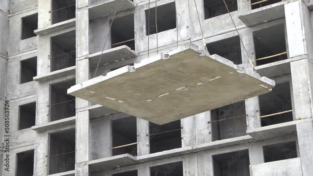 Concrete building and tower crane's hook over it in the construction ...