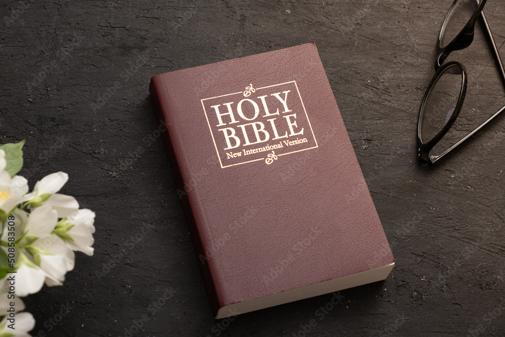Top view of the Holy Bible on the desktop with glasses. The concept of ...