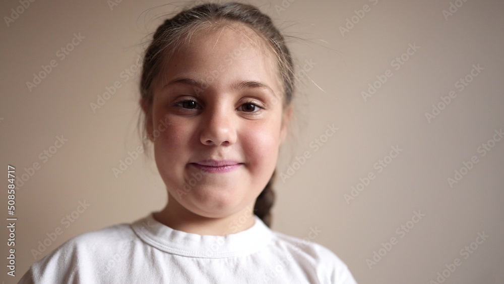 little girl smiling. the child looks close-up into the video camera ...