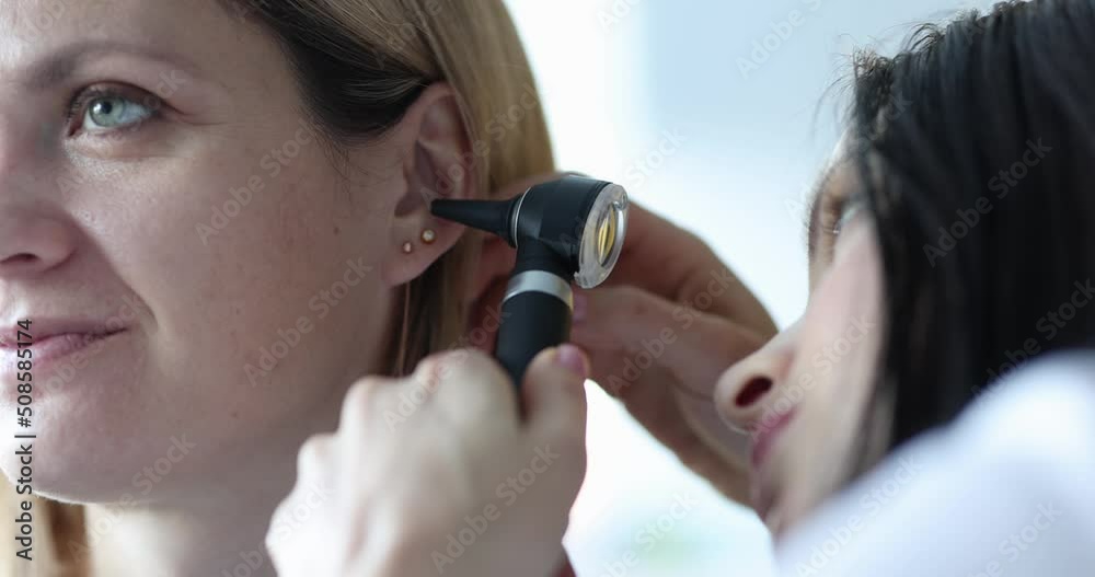 ENT diagnosis and examination of the ear with otoscope of woman Stock ...