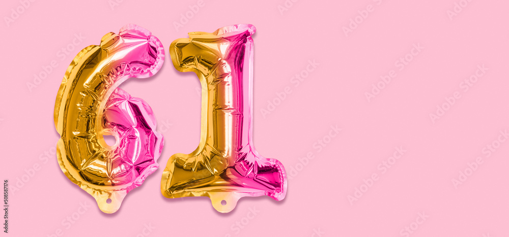 Rainbow foil balloon number, digit sixty one on a pink background ...